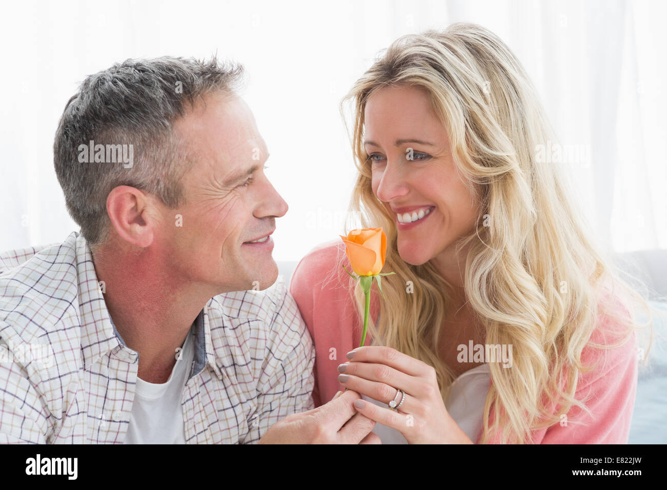 Happy woman smiling at partner who has given her a rose Stock Photo - Alamy