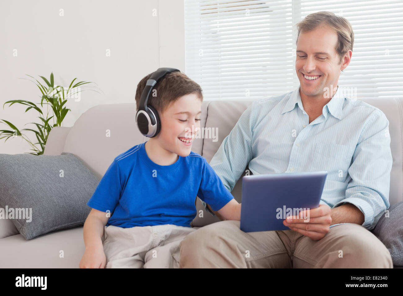 Casual father and son using tablet pc Stock Photo - Alamy