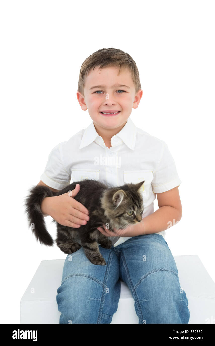 Smiling boy sitting cuddling a grey kitten Stock Photo - Alamy