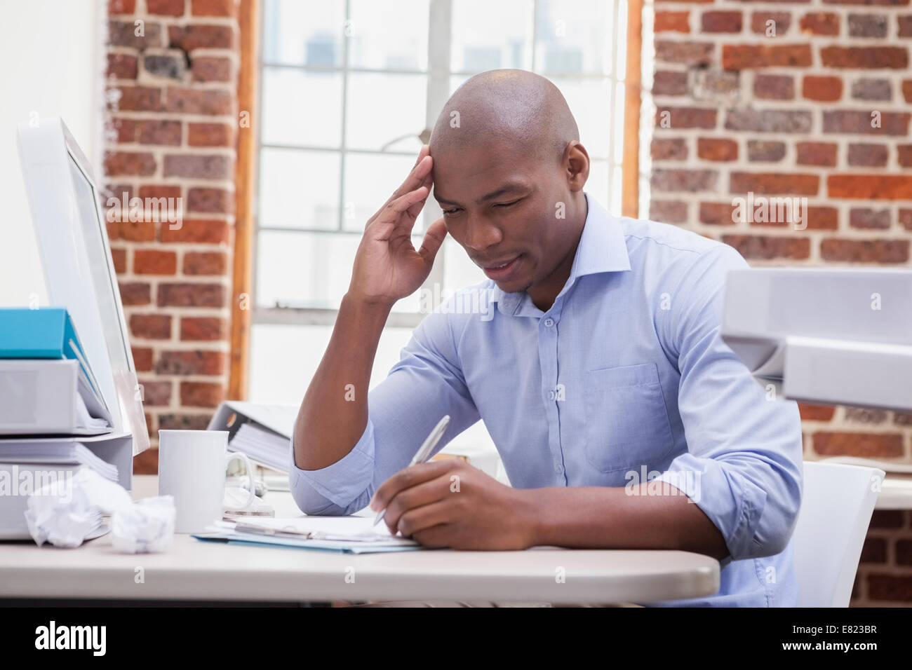 Casual businessman writing at his desk Stock Photo - Alamy