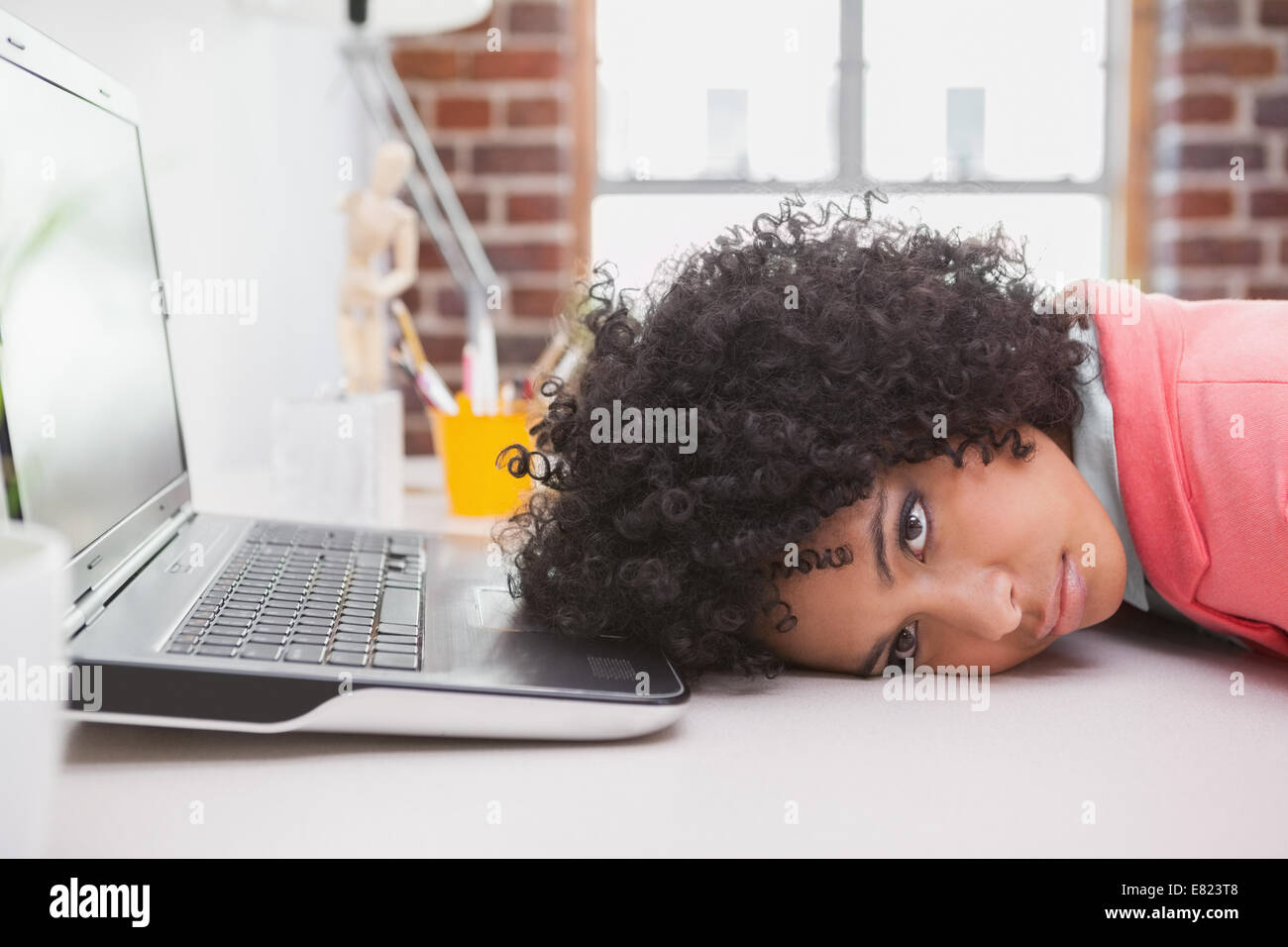 Casual businesswoman resting head on desk Stock Photo - Alamy