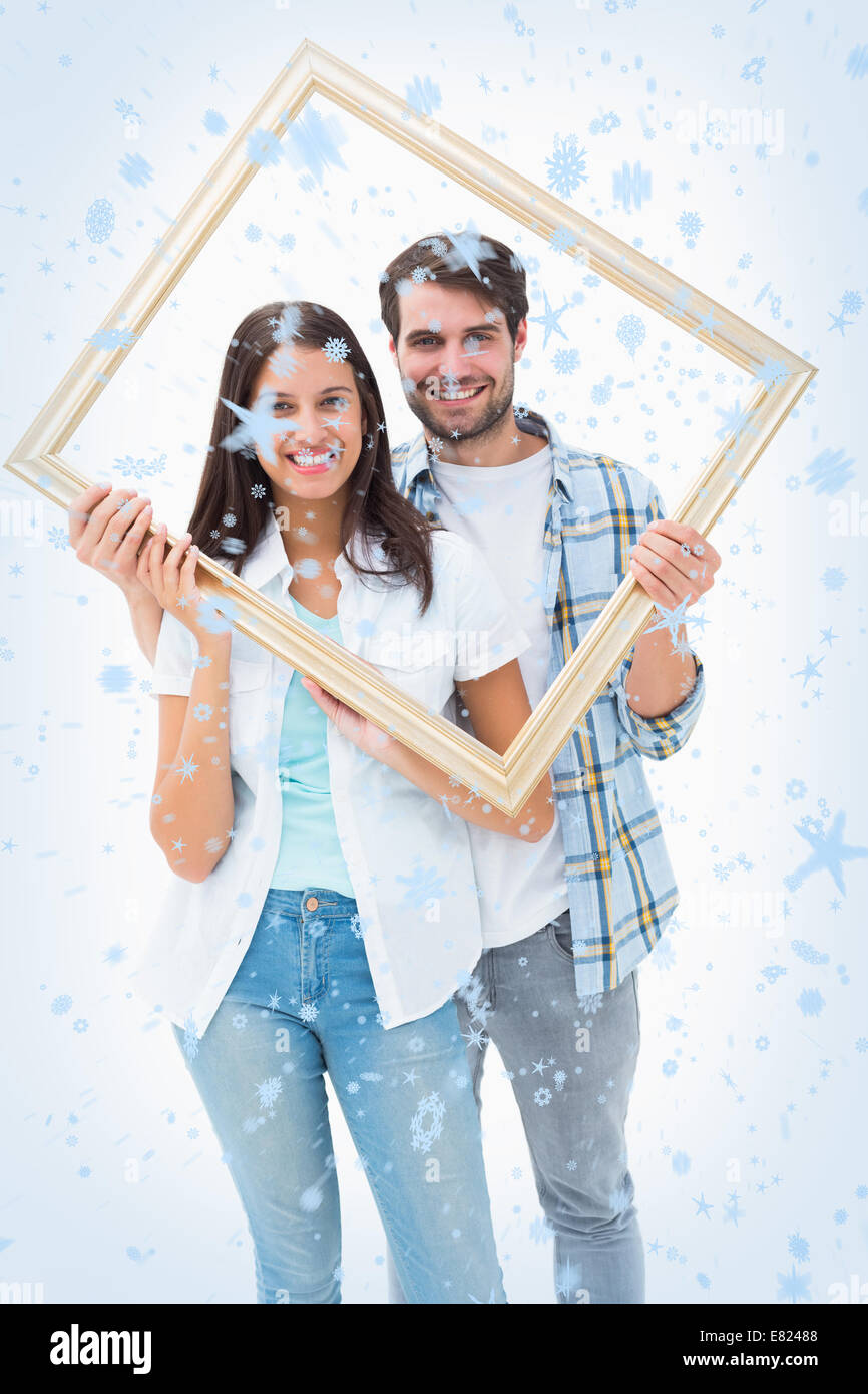 Happy young couple holding picture frame Stock Photo - Alamy