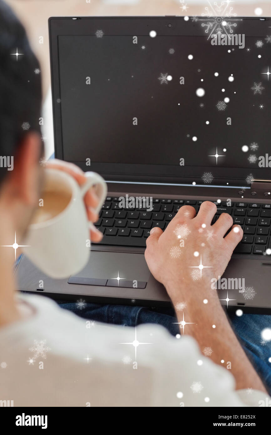 Over shoulder view of young man using his laptop Stock Photo - Alamy