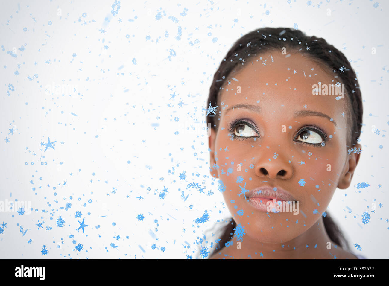 Close up of womans face looking upwards diagonally on white background ...