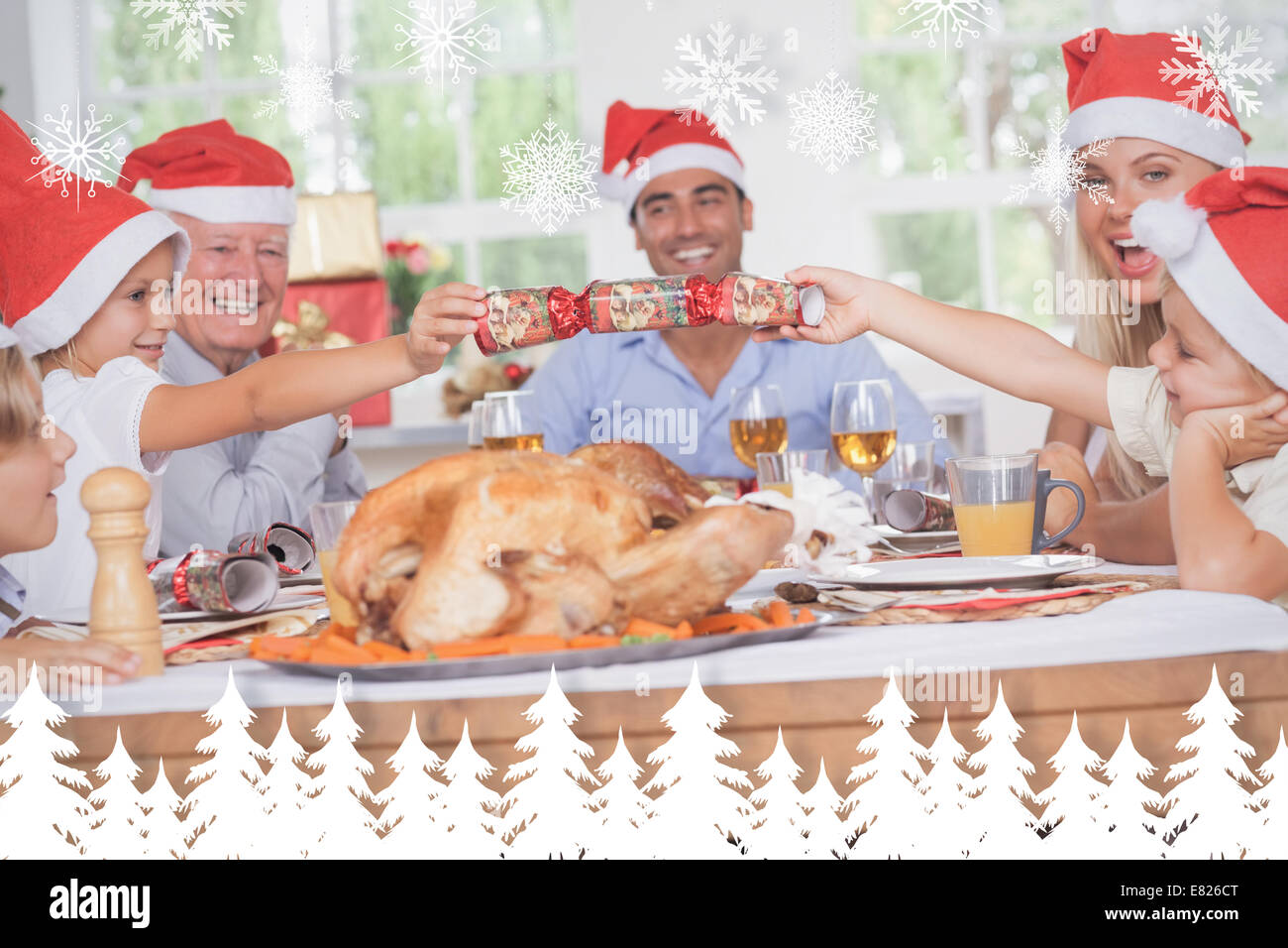 Composite image of siblings pulling a christmas cracker Stock Photo - Alamy