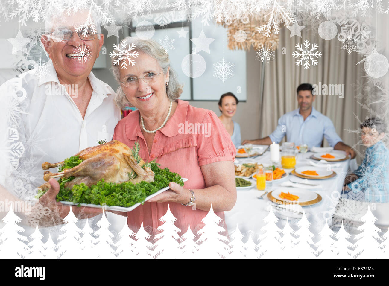 Grandparents holding chicken roast with family at dining table Stock ...