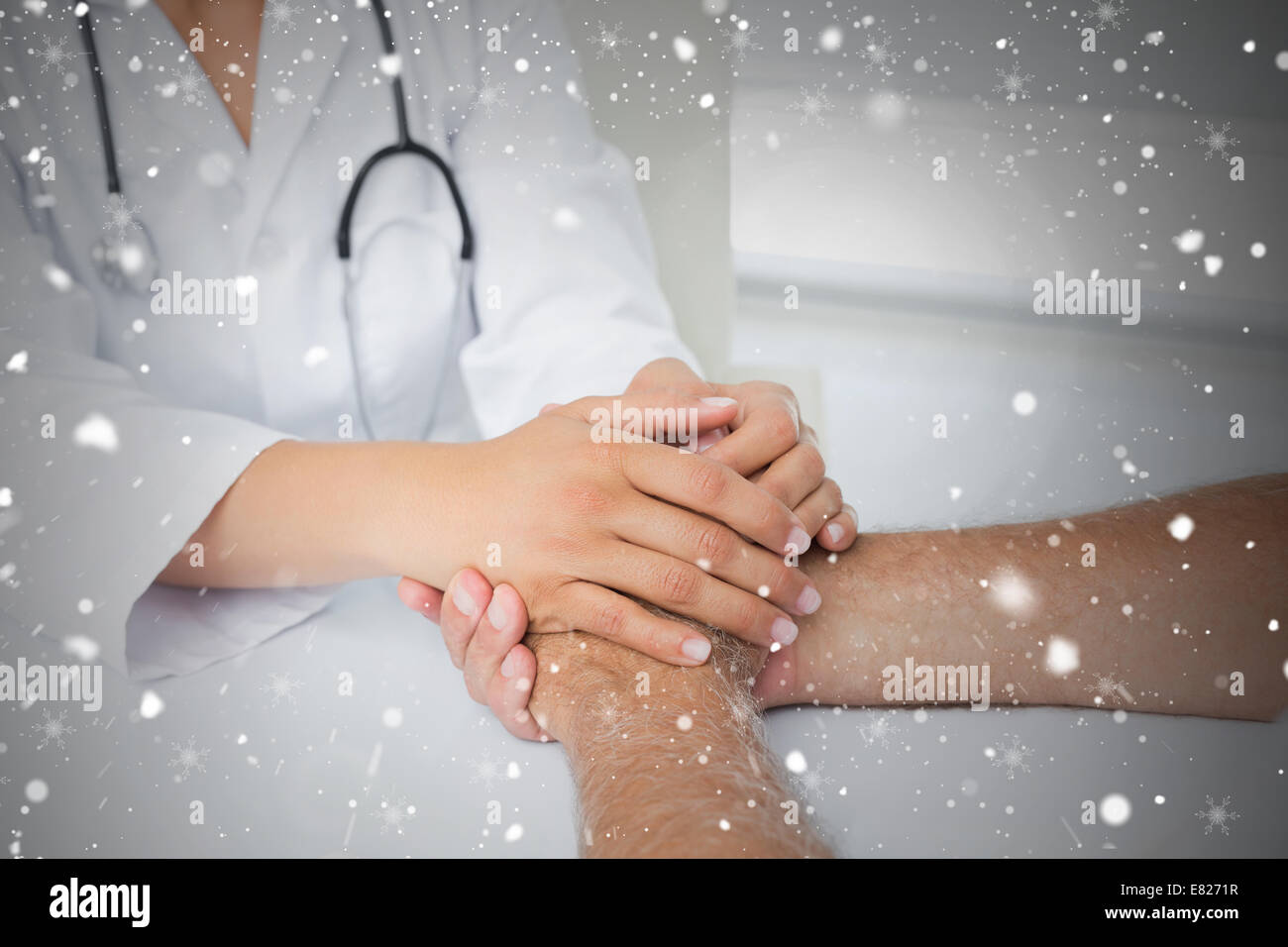 Close up mid section of a doctor holding patients hands Stock Photo - Alamy