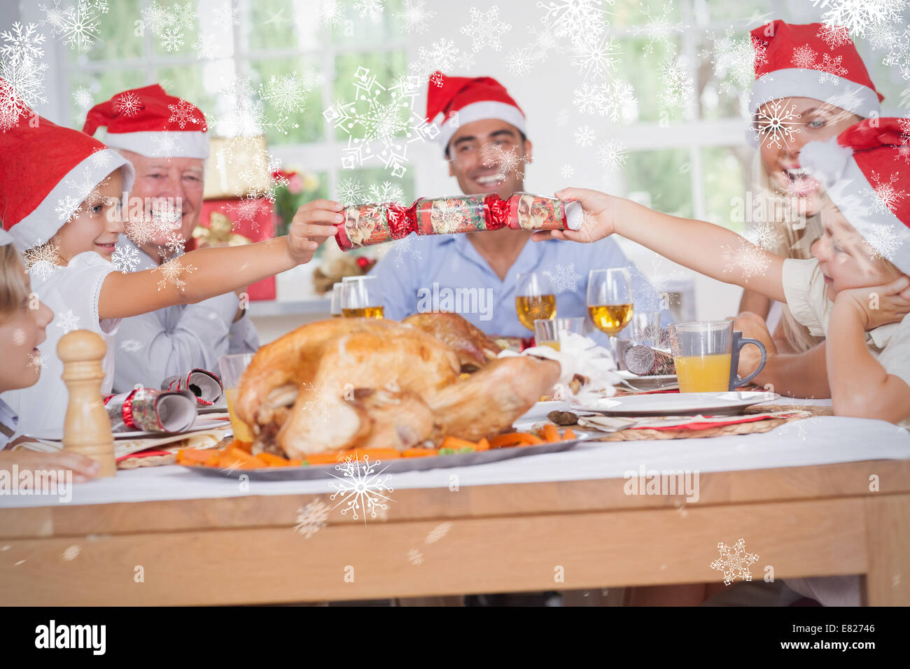 Composite image of siblings pulling a christmas cracker Stock Photo - Alamy