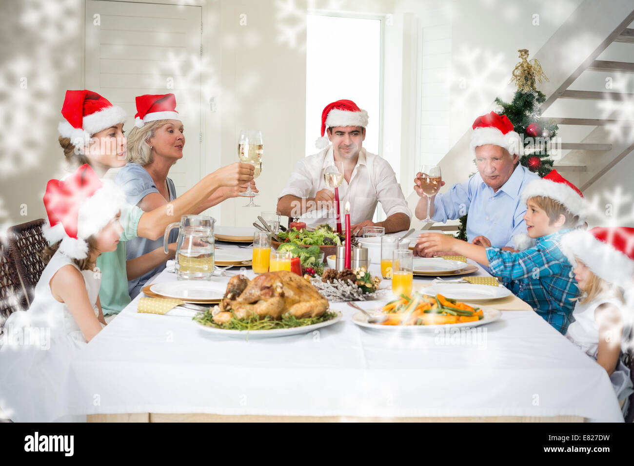 Composite image of family toasting wine while having christmas meal ...