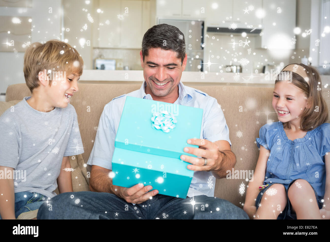 Composite image of father opening gift given by children on sofa Stock ...