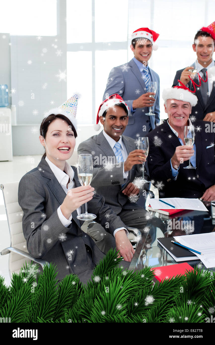 Manager and his team with novelty christmas hat toasting at a party ...