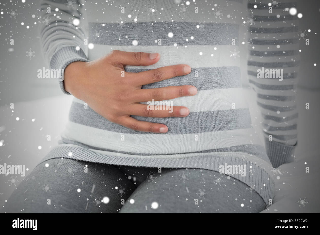 Mid section of a woman with stomach pain sitting in bed Stock Photo - Alamy