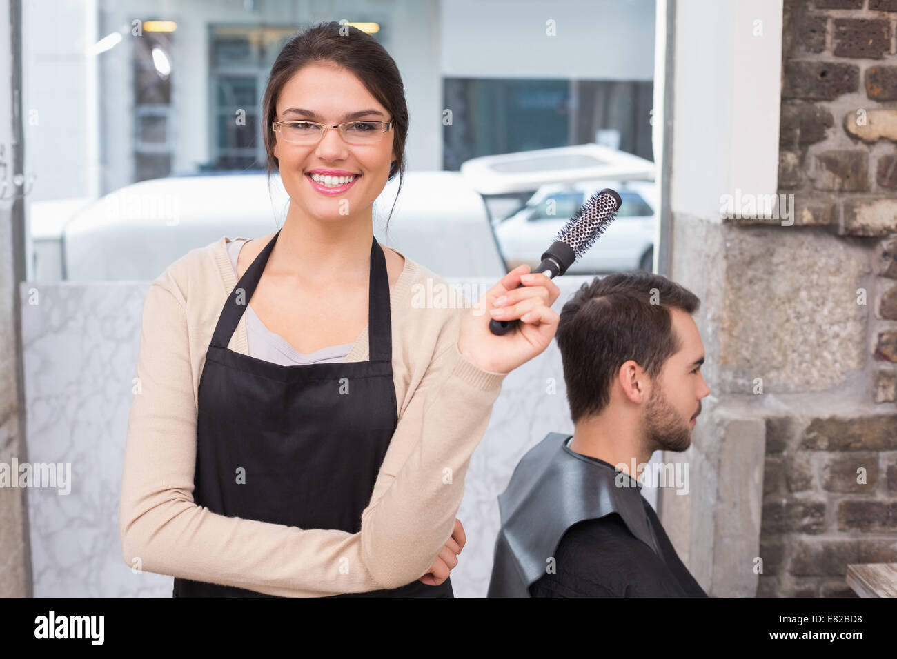 Pretty hair stylist smiling at camera Stock Photo - Alamy