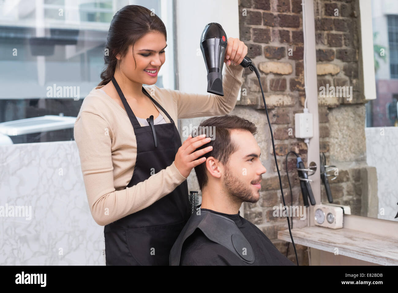 Hair stylist drying mans hair Stock Photo - Alamy