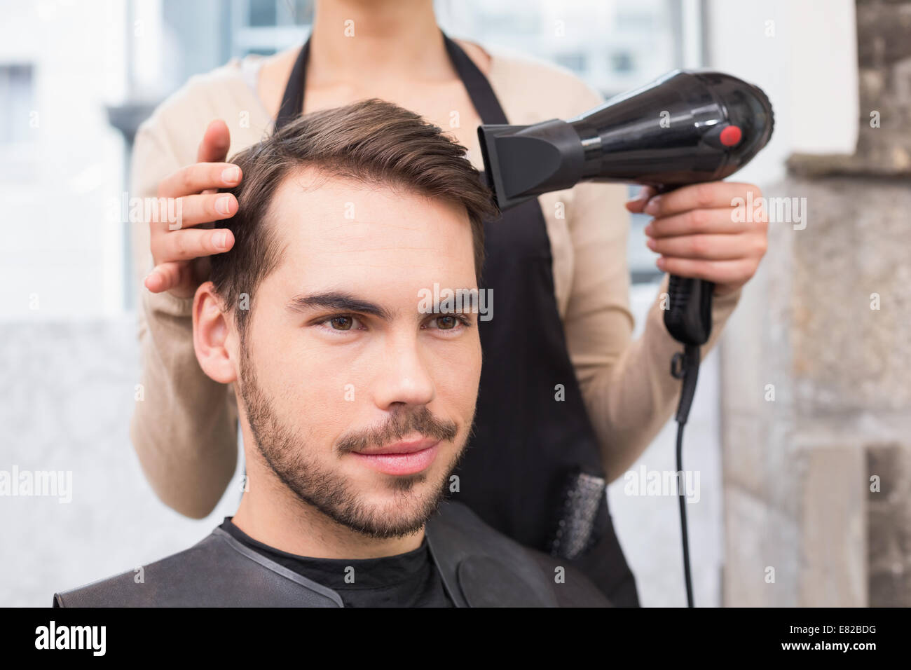 Hair stylist drying mans hair Stock Photo - Alamy