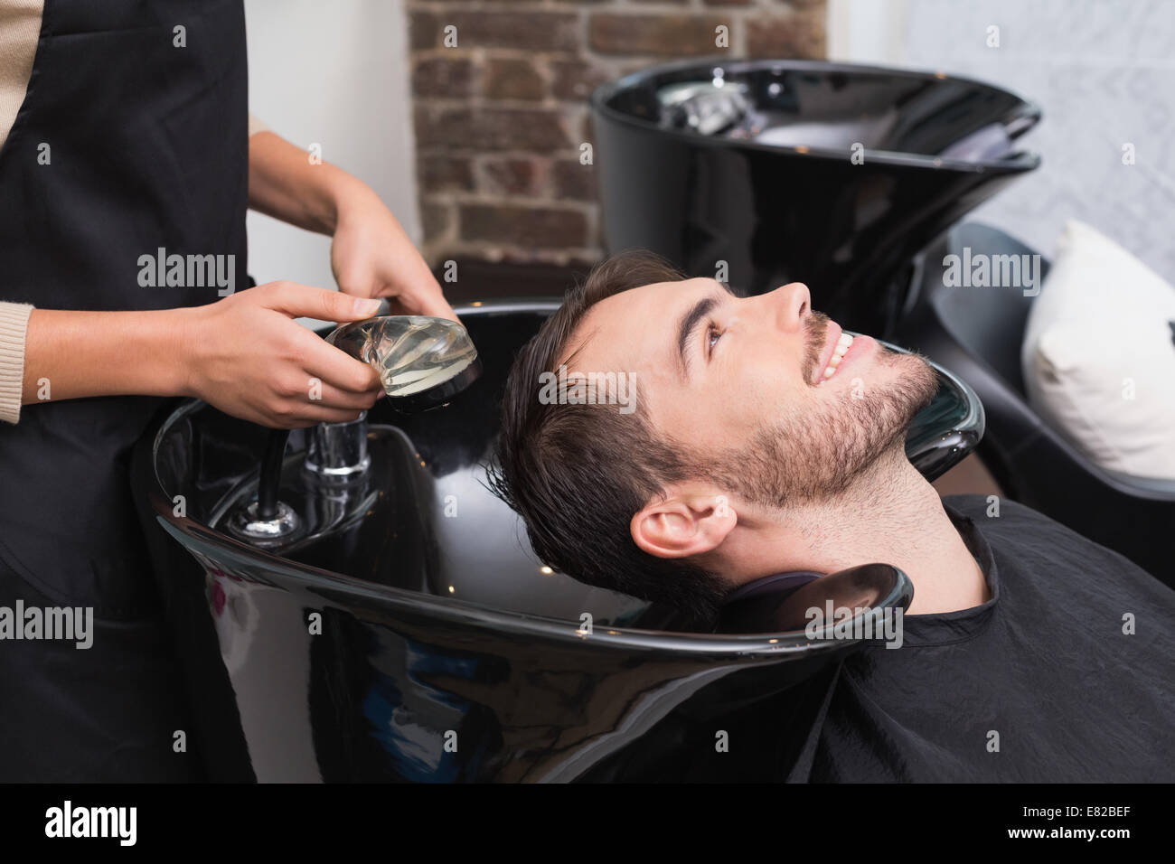 Hair stylist washing mans hair Stock Photo - Alamy