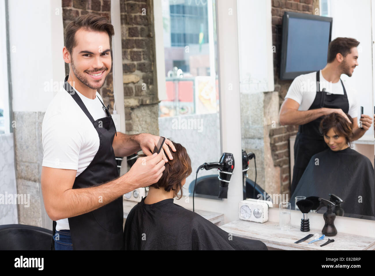 Handsome hair stylist with client Stock Photo - Alamy