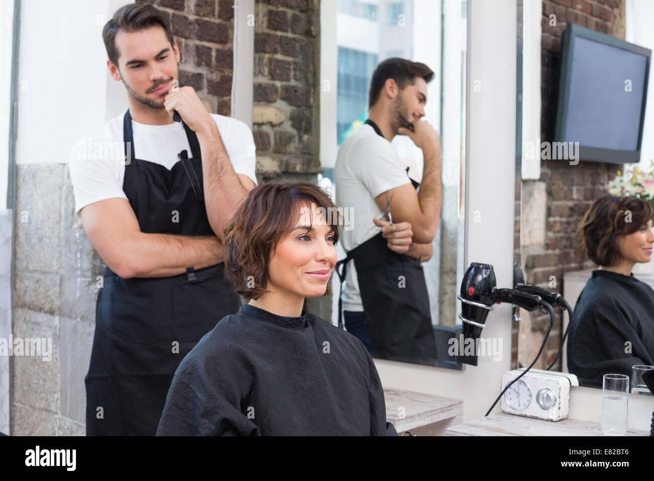 Handsome hair stylist with client Stock Photo - Alamy