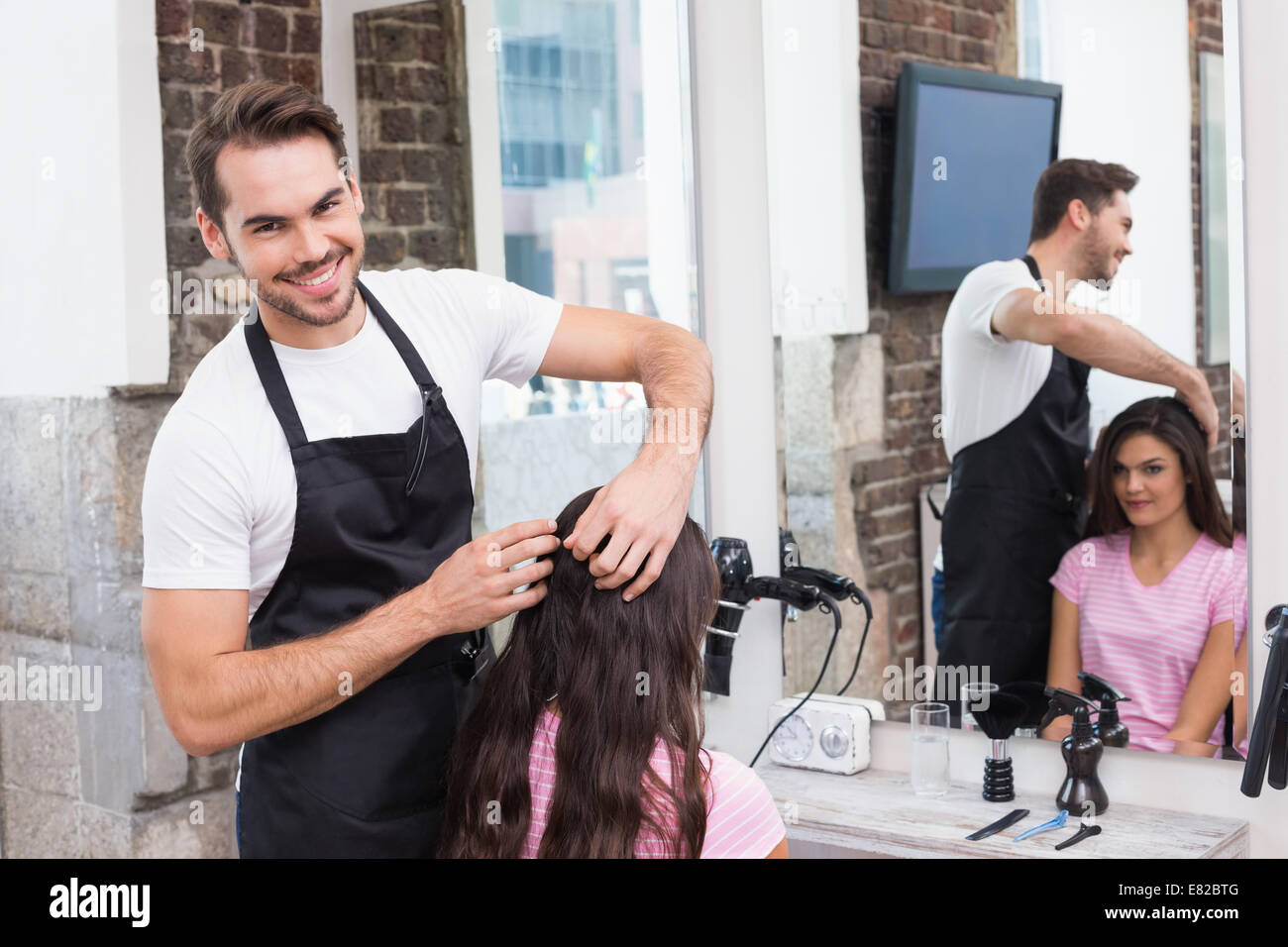 Handsome hair stylist with client Stock Photo - Alamy