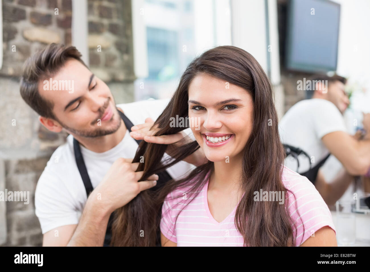 Handsome hair stylist with client Stock Photo - Alamy
