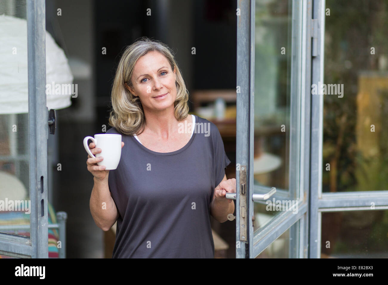 Woman opening window Stock Photo - Alamy