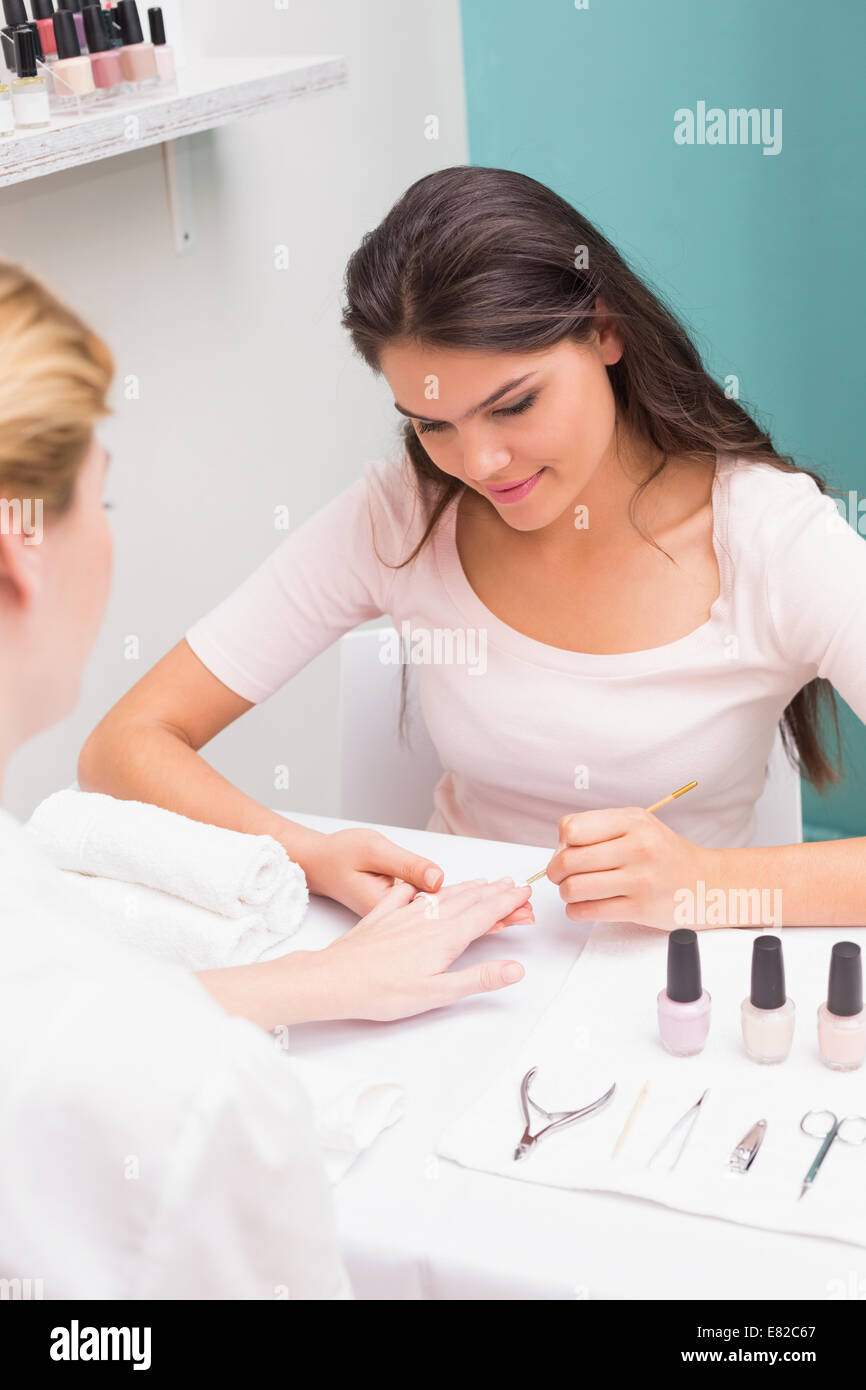 Nail technician giving customer a manicure Stock Photo - Alamy