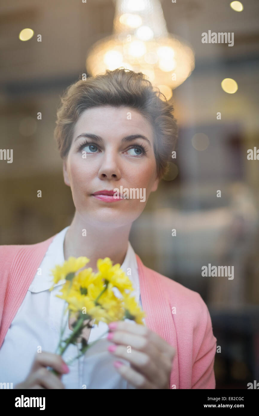 Pretty blonde holding yellow flowers Stock Photo - Alamy