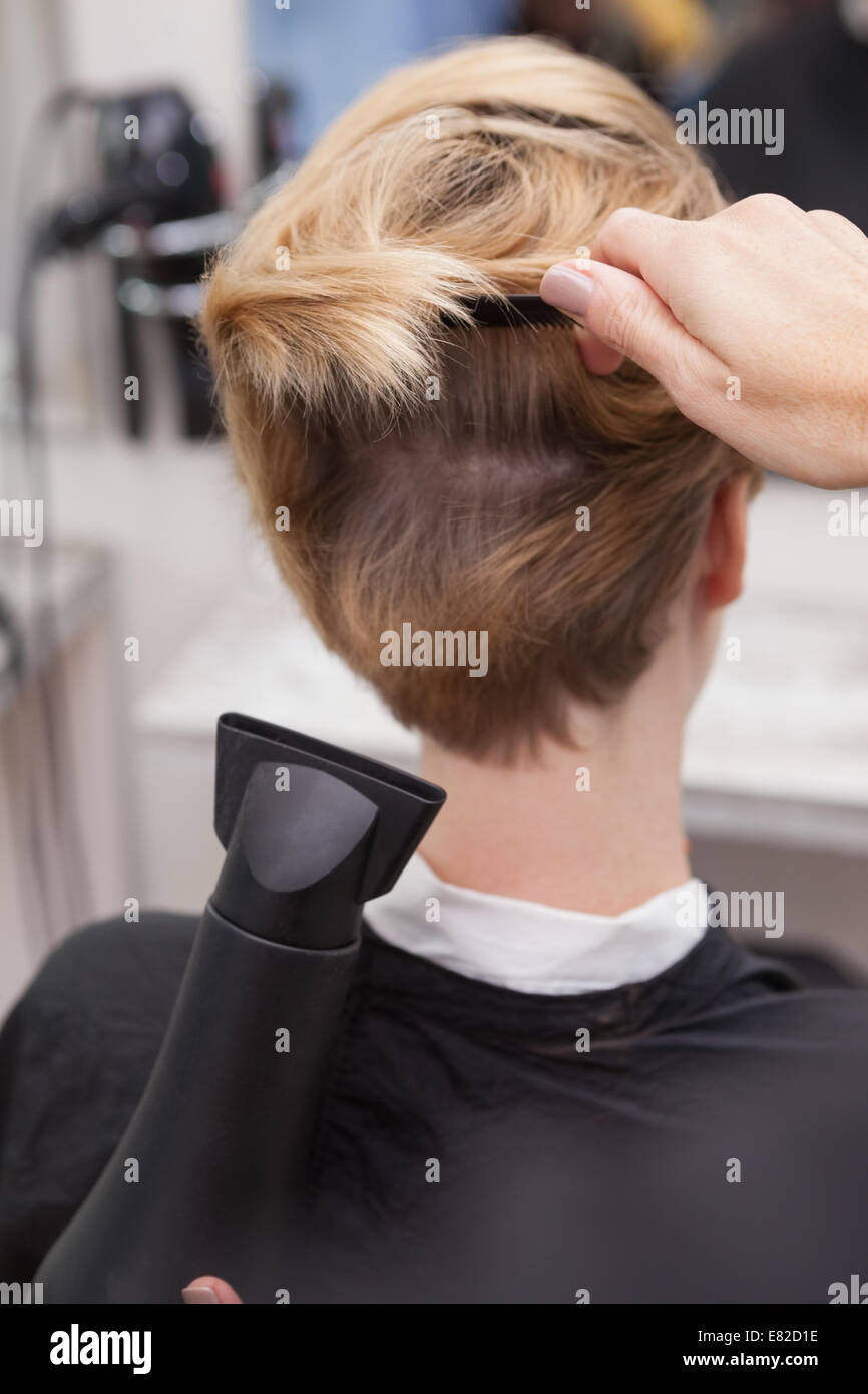 Hairdresser smiling and styling customers hair Stock Photo - Alamy