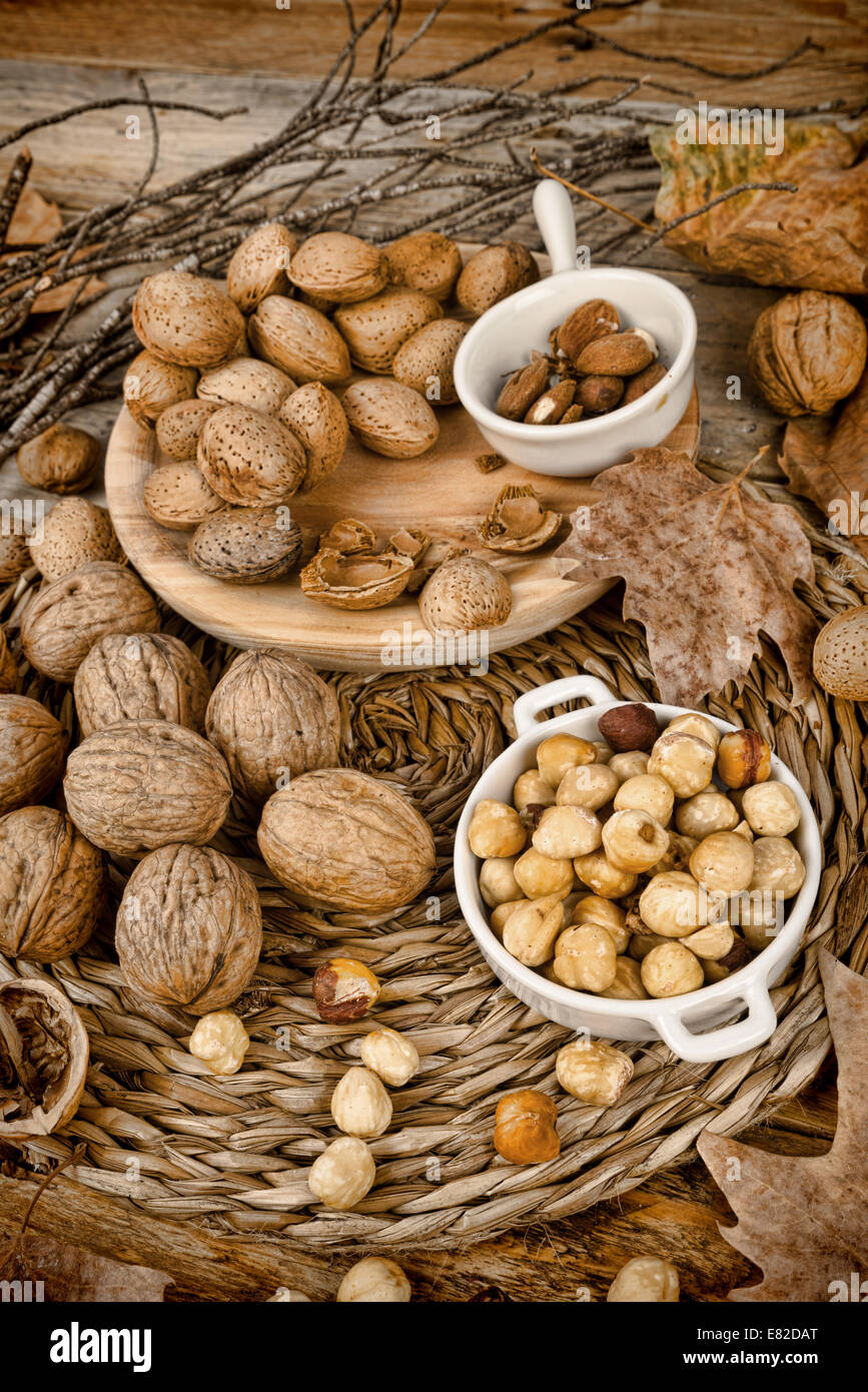 Assorted nuts displayed on a rustic wooden table Stock Photo - Alamy