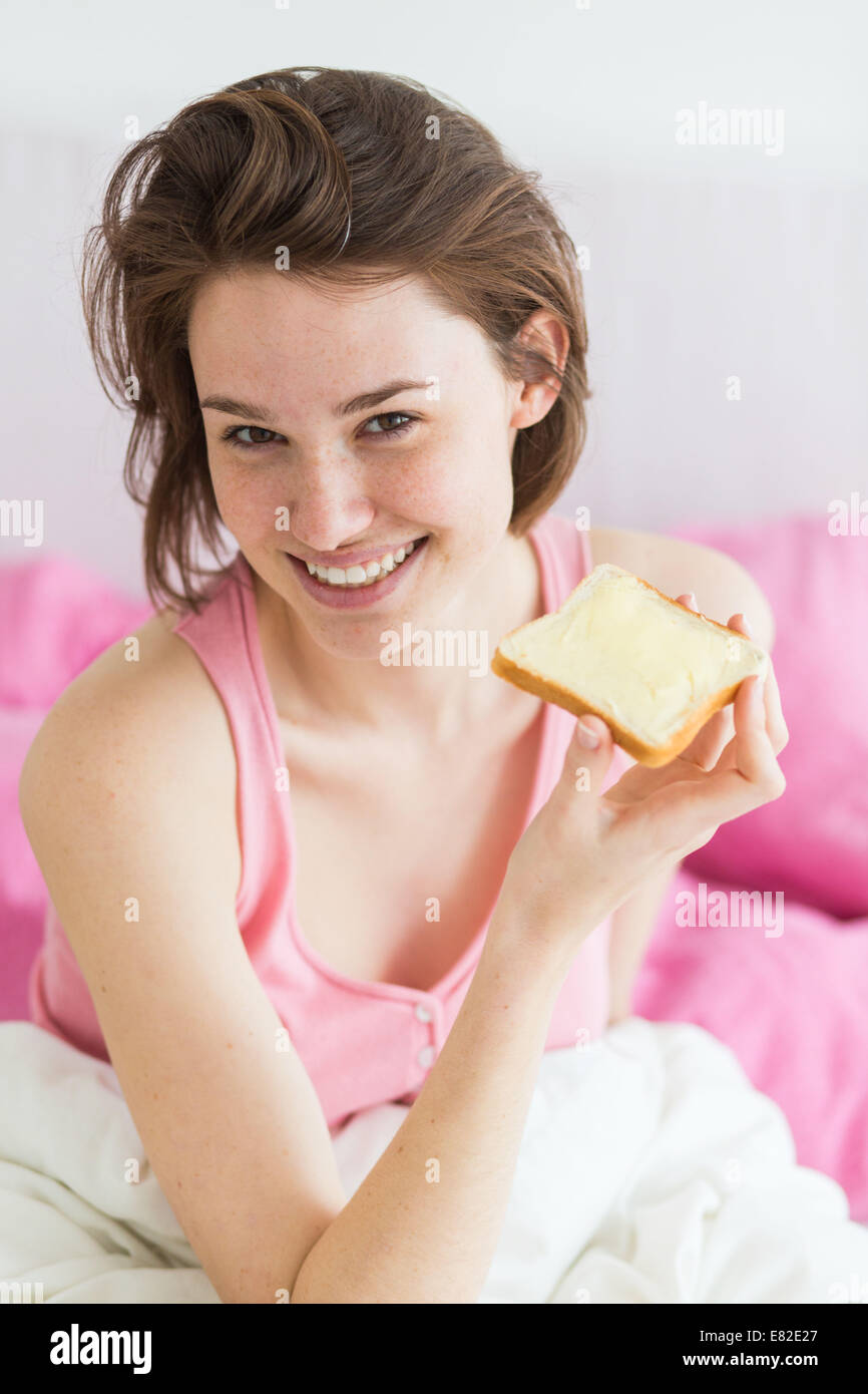 Woman eating toast Stock Photo - Alamy