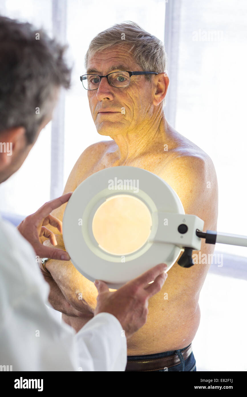 Doctor examining the skin of a man Stock Photo - Alamy