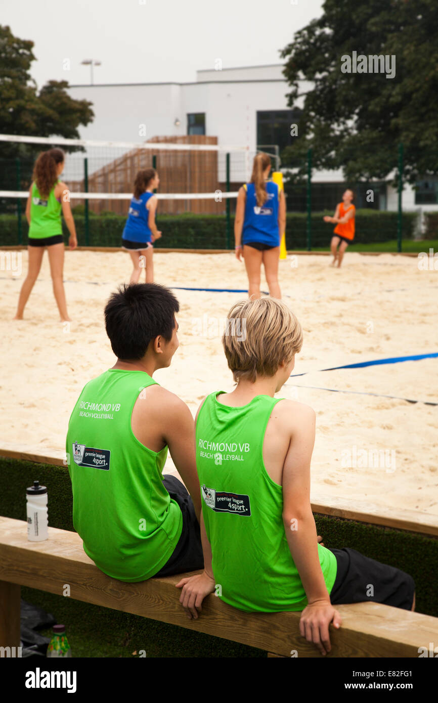 Two young people wait on the bench for their turn to play on a park ...