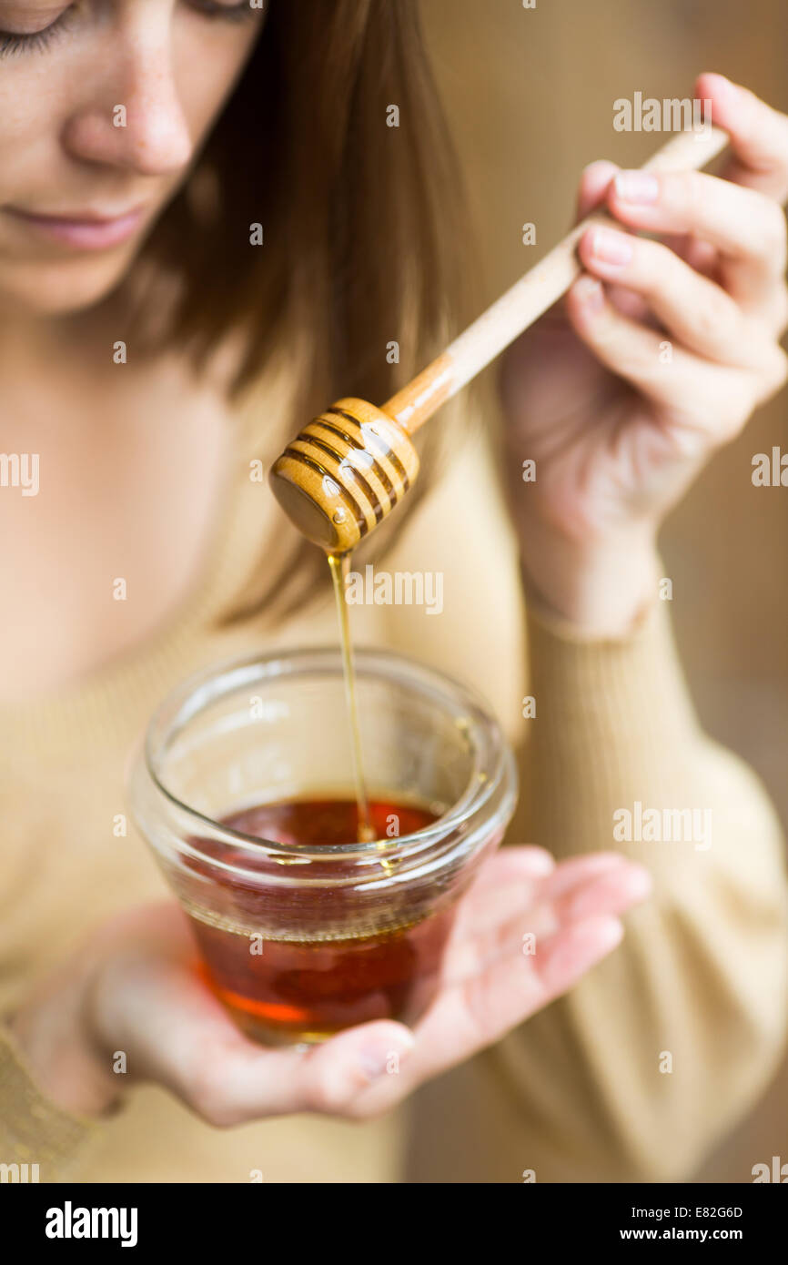 Woman eating honey Stock Photo - Alamy