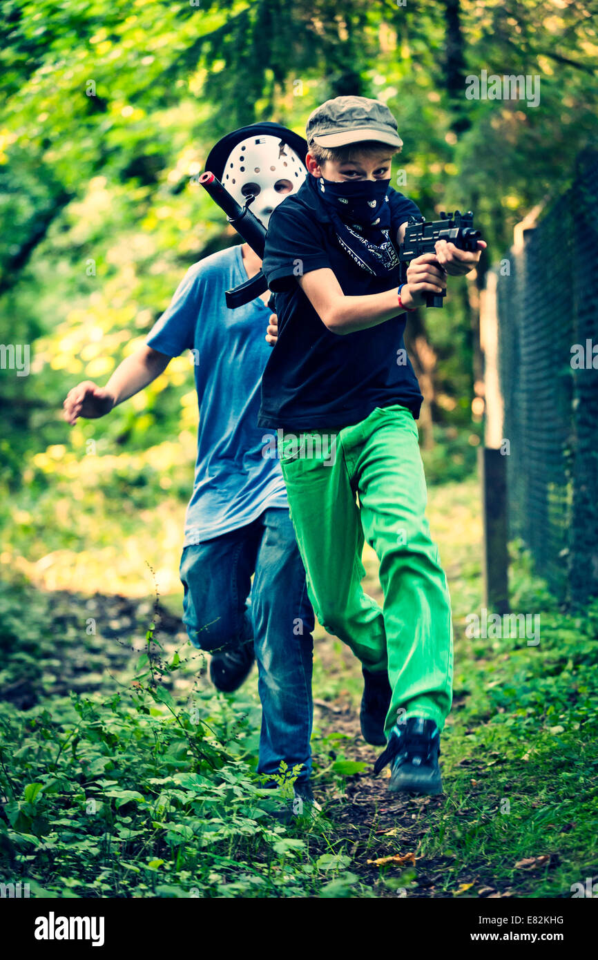 Two masked boys playing with toy weapons Stock Photo - Alamy