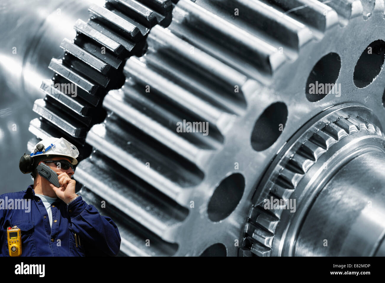 engineer against large cogwheels machinery Stock Photo - Alamy
