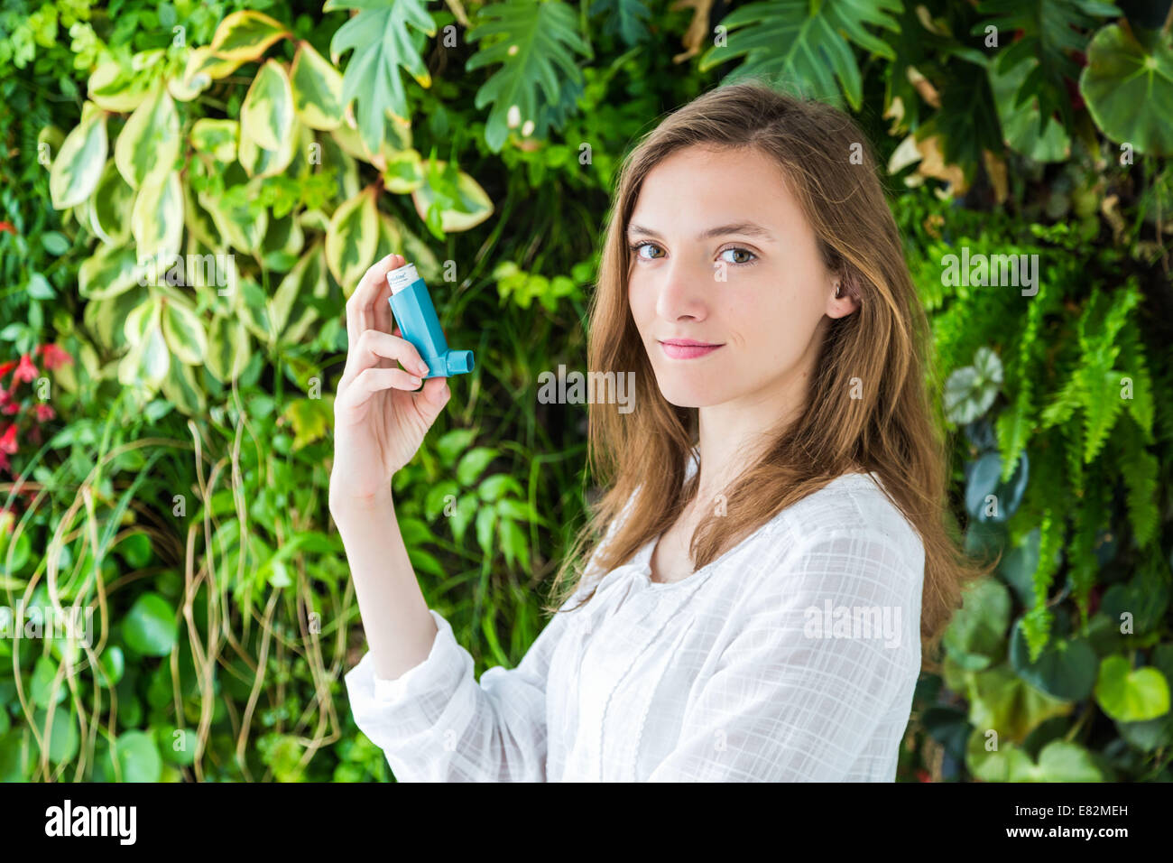 Woman using an aerosol inhaler that contains bronchodilator for the ...