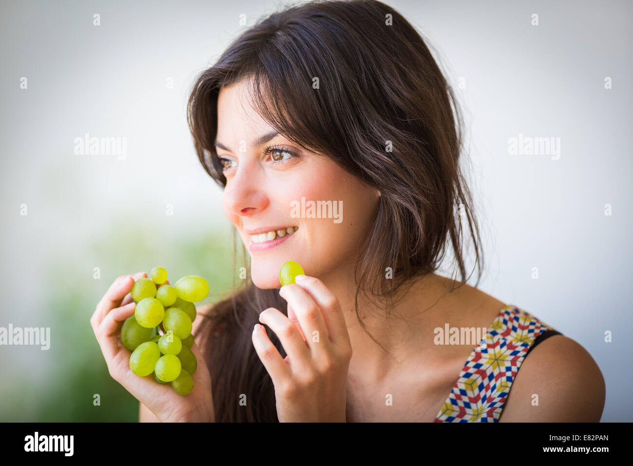 Woman eating grape Stock Photo - Alamy