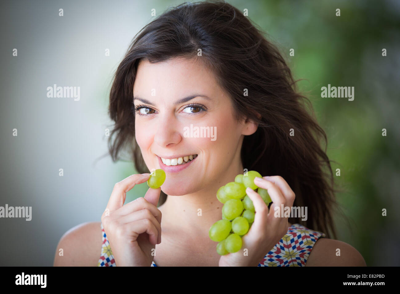 Woman eating grape Stock Photo - Alamy