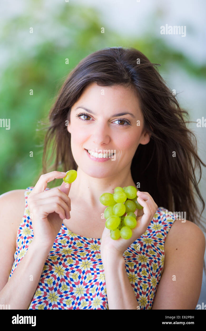 Woman eating grape Stock Photo - Alamy