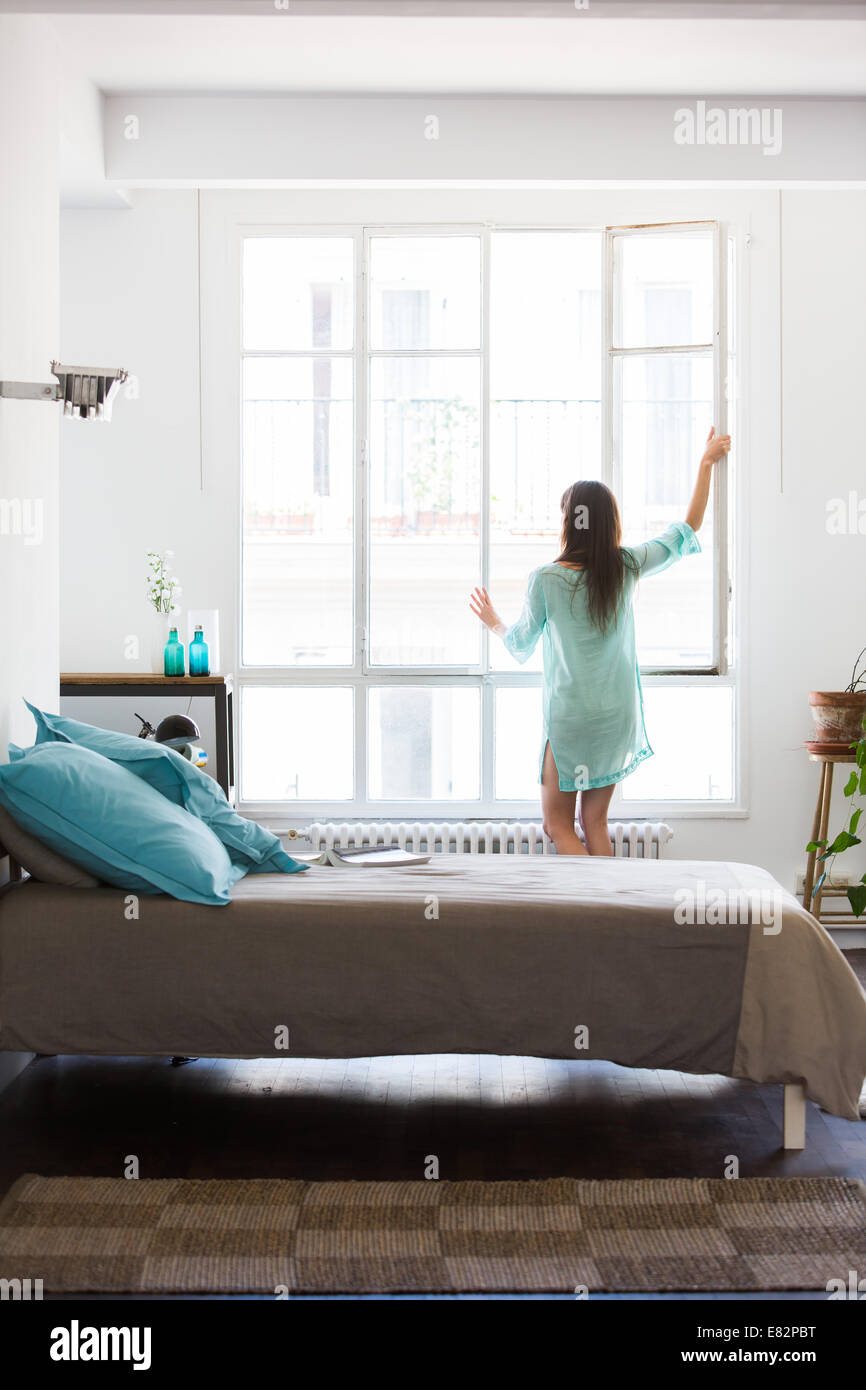 Woman opening window Stock Photo - Alamy