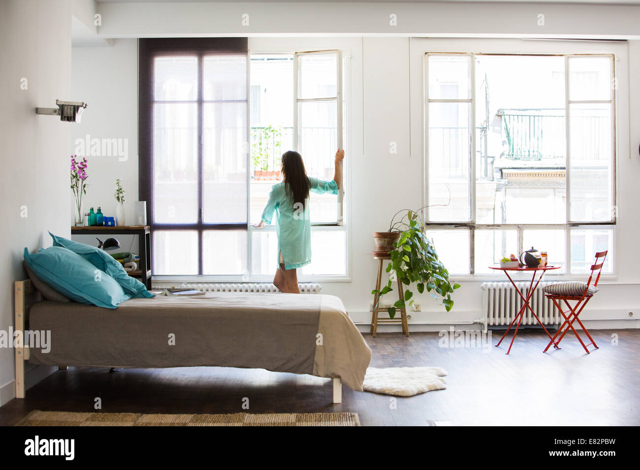 Woman opening window Stock Photo - Alamy