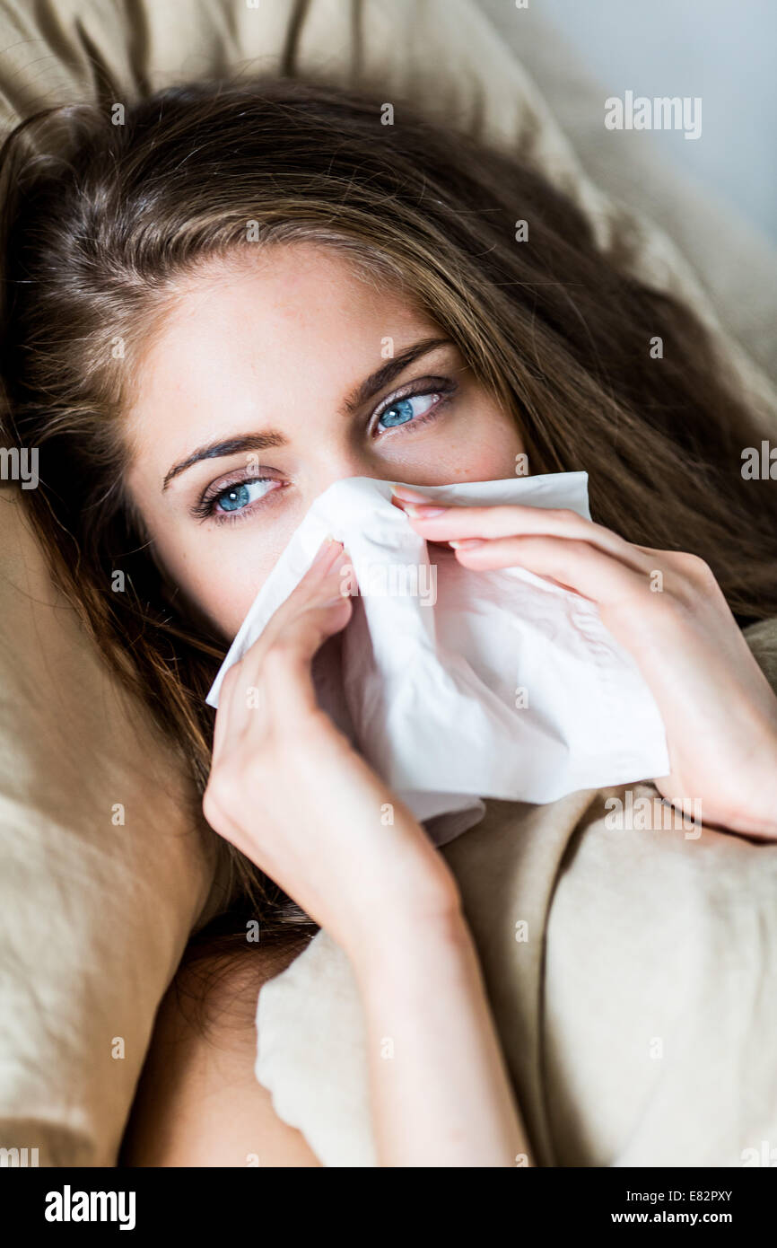 Woman with a cold using tissue Stock Photo - Alamy