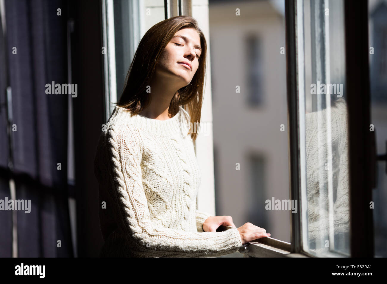 Woman looking through the window Stock Photo - Alamy