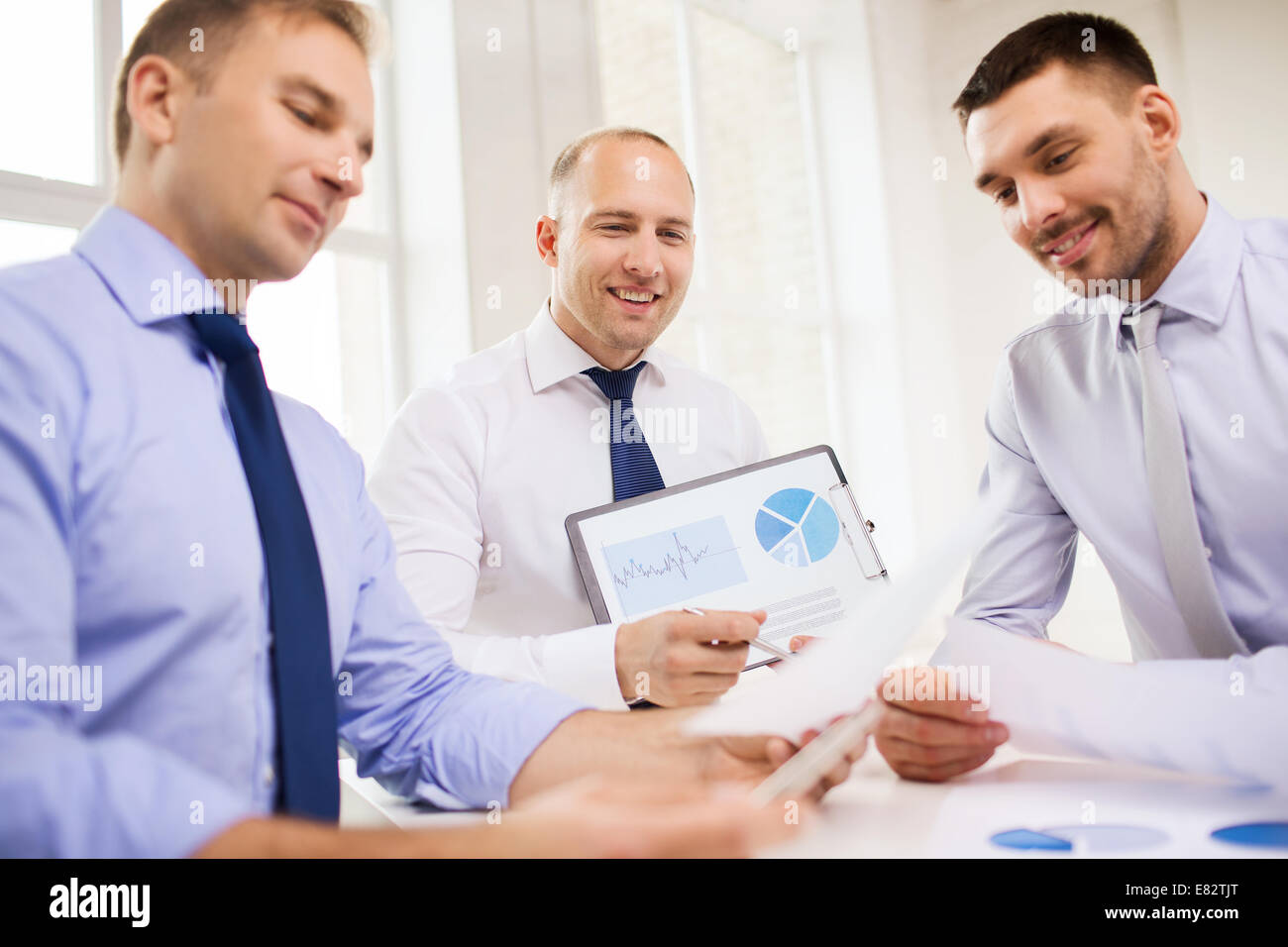 smiling businessmen with papers in office Stock Photo - Alamy