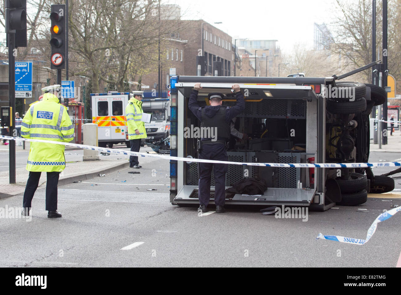 A police riot van flips over on its side after crashing into a ...