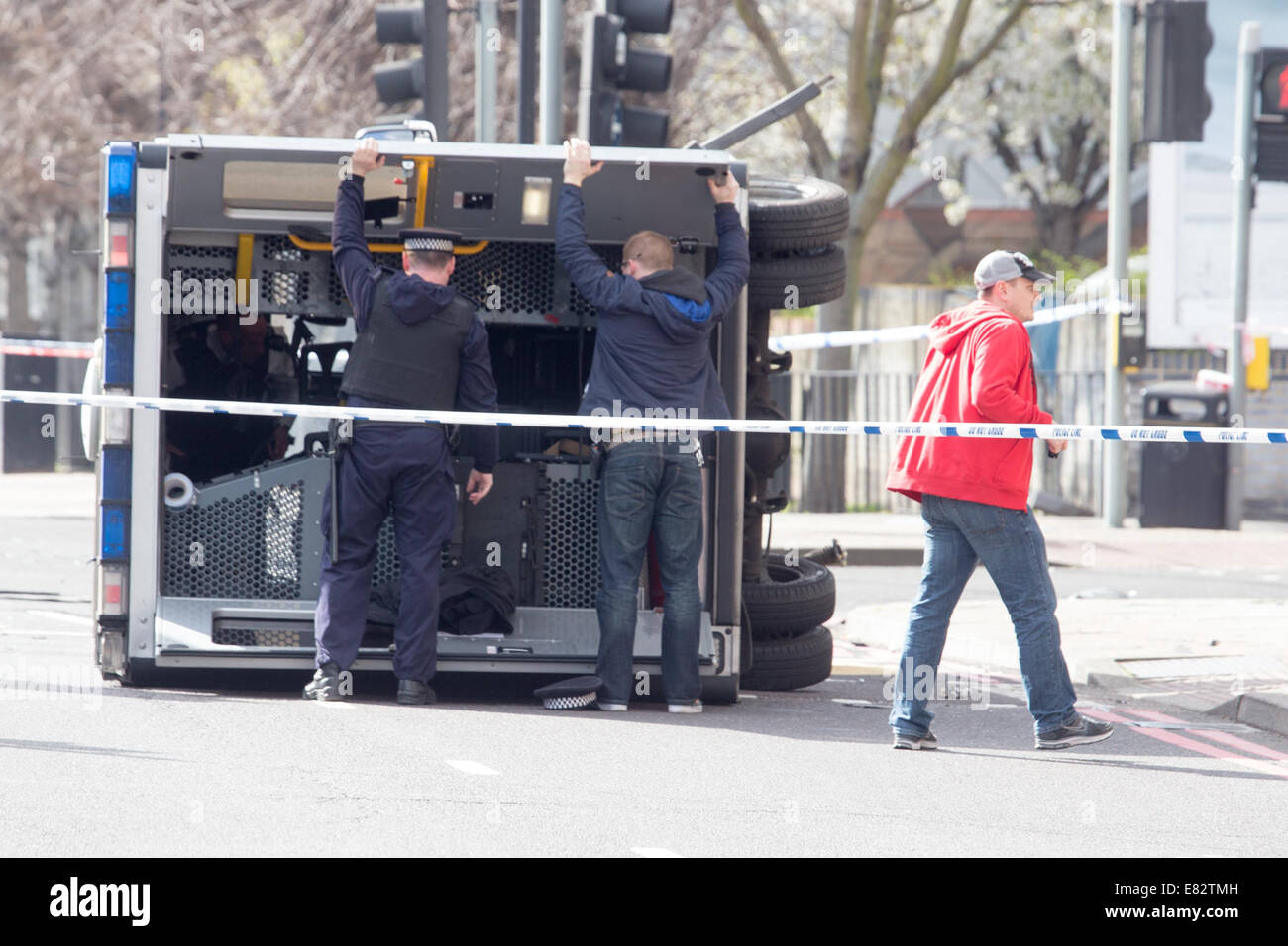 A police riot van flips over on its side after crashing into a ...
