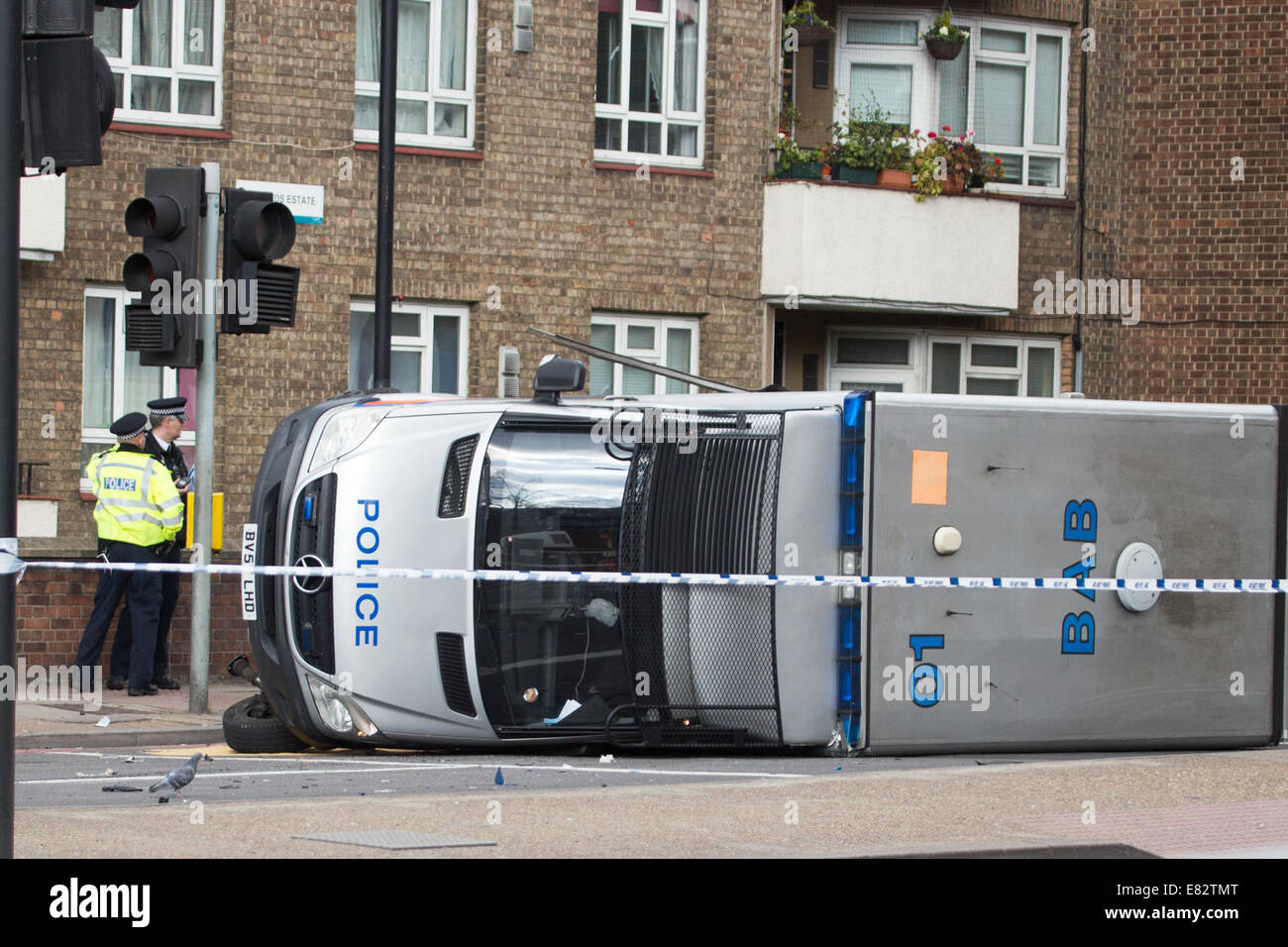 A police riot van flips over on its side after crashing into a ...