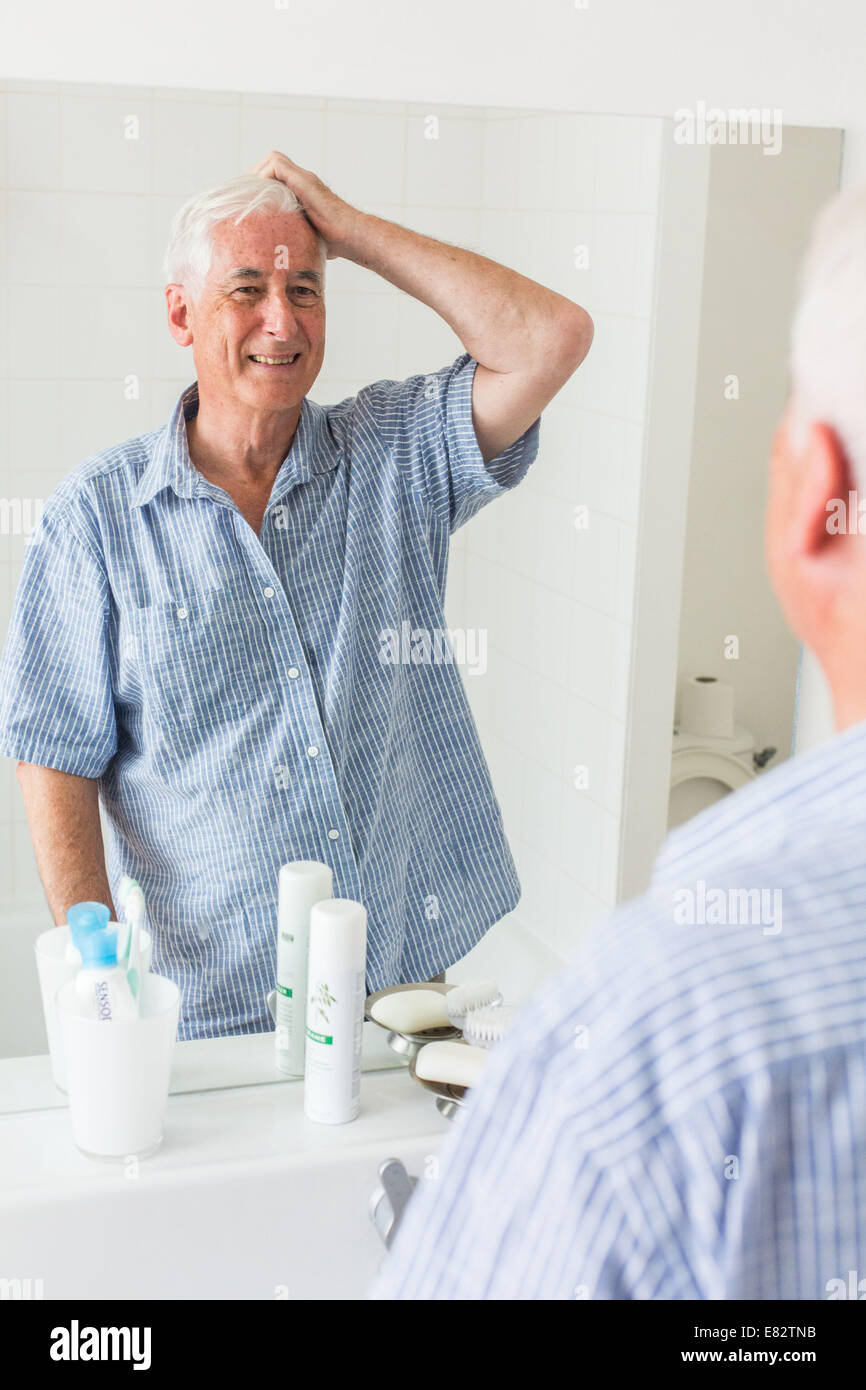Woman checking her face in the mirror Stock Photo - Alamy