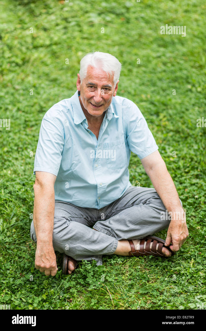 Man sitting on lawn Stock Photo - Alamy