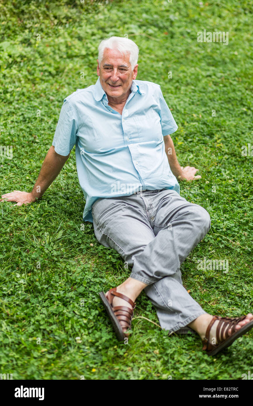 Man sitting on lawn Stock Photo - Alamy